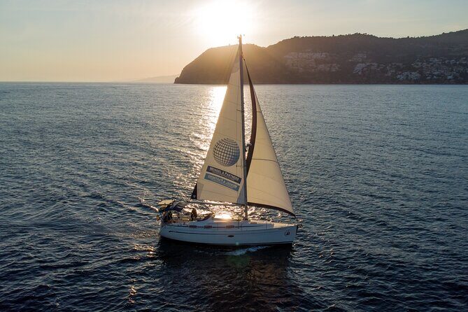 Sailing at sunset along the cliffs of Maro-Compartida - The Sum Up